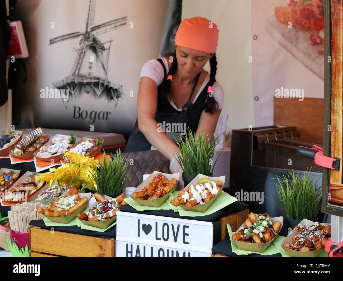 Une jeune femme sur un marché qui vend différentes sortes de frites ...