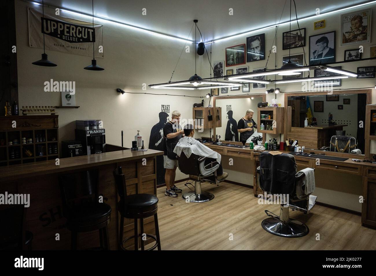 Un coiffeur donne à un client une coupe de cheveux dans un salon de coiffure « Helby's Barber ...
