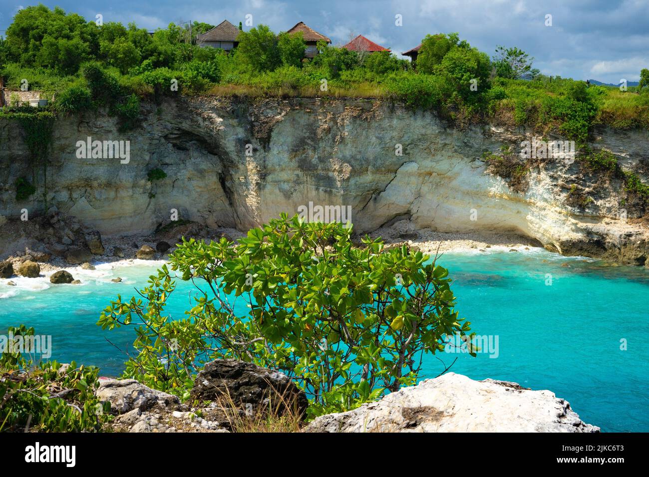 Vue sur le paysage d'une colline verdoyante au bord d'une eau bleue et ...