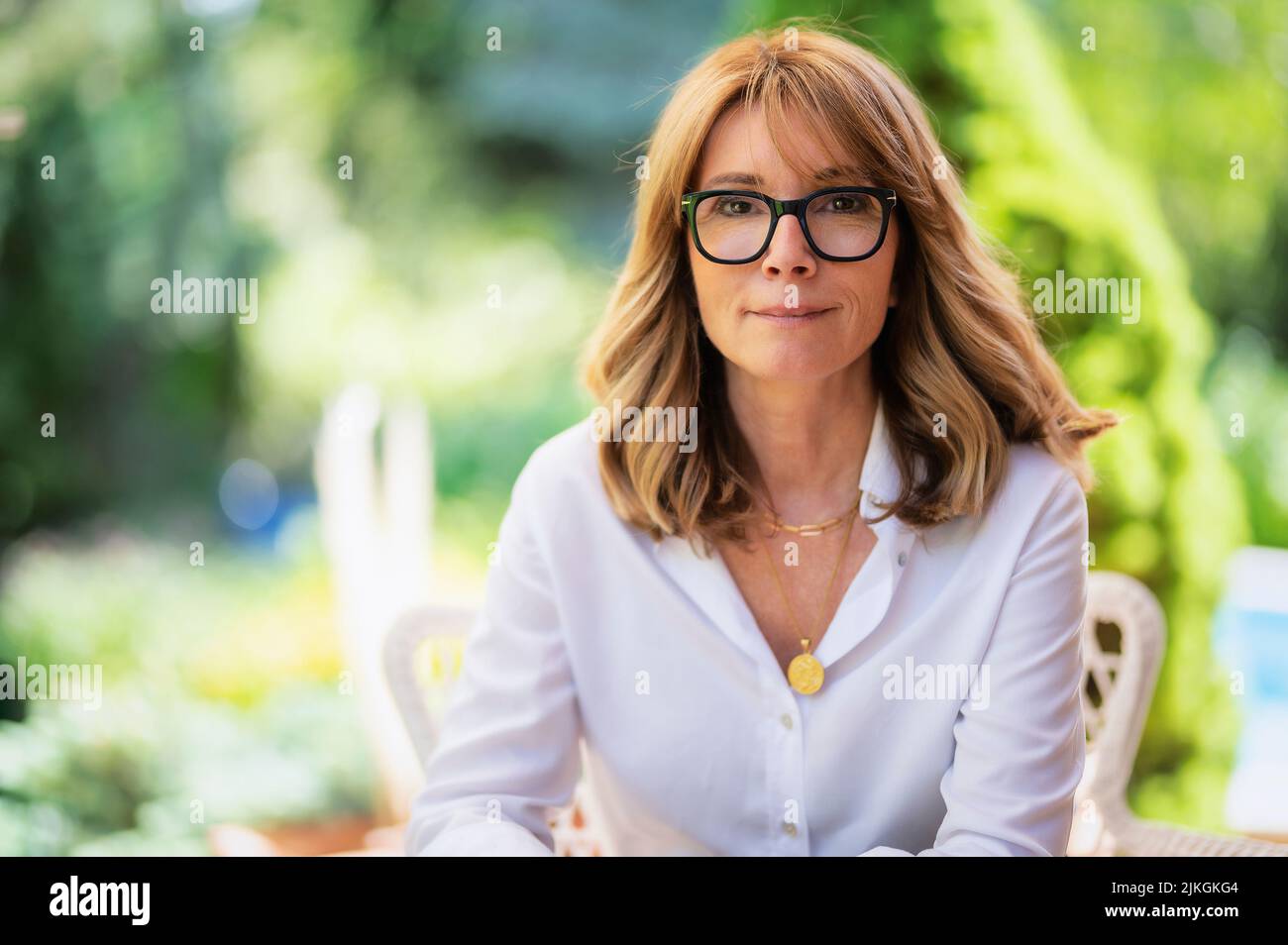 Femme assise dans une chaise longue Banque de photographies et d’images à haute résolution - Alamy
