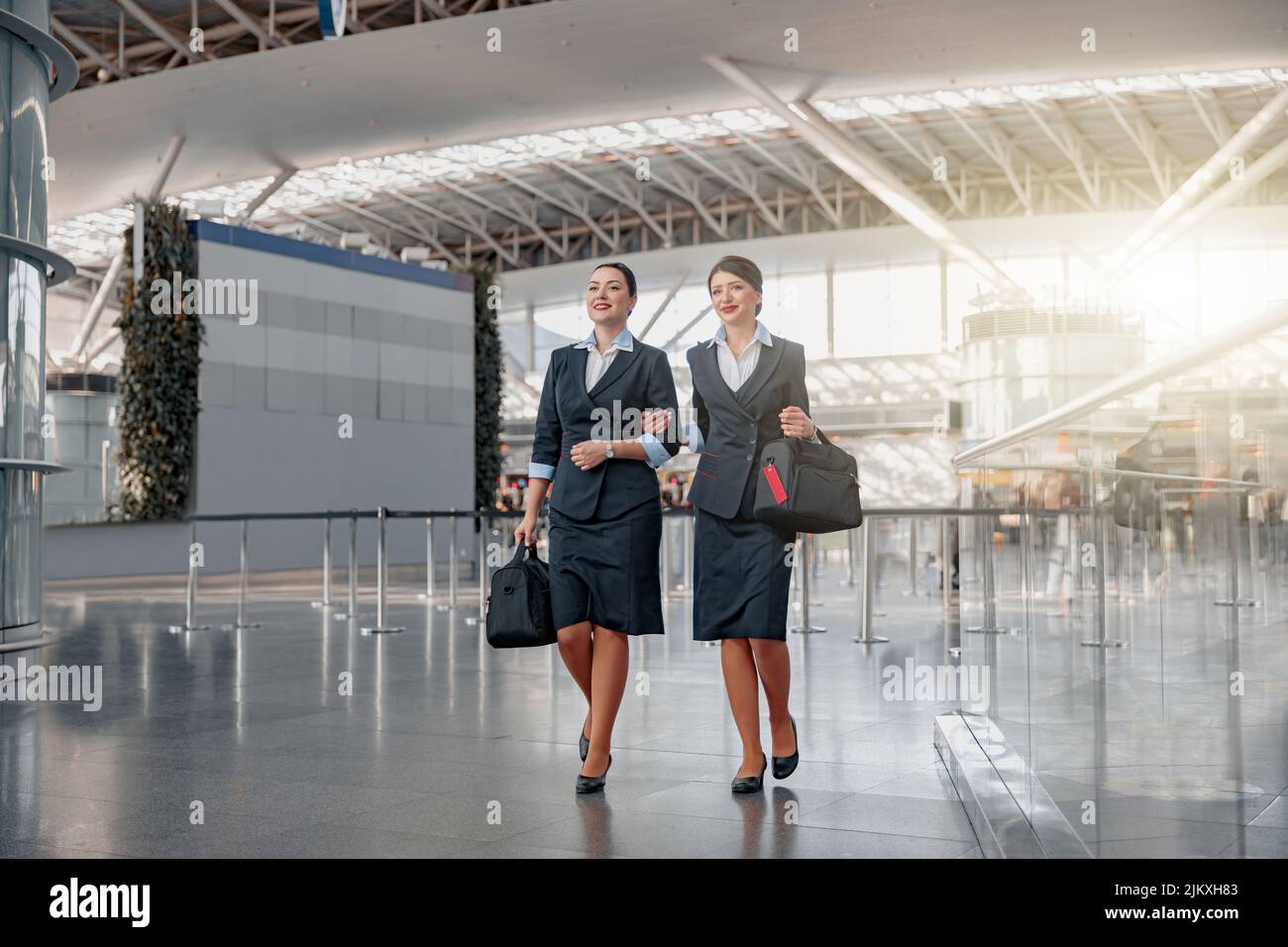 Deux agents de bord avec des bagages traversant le terminal Photo Stock ...
