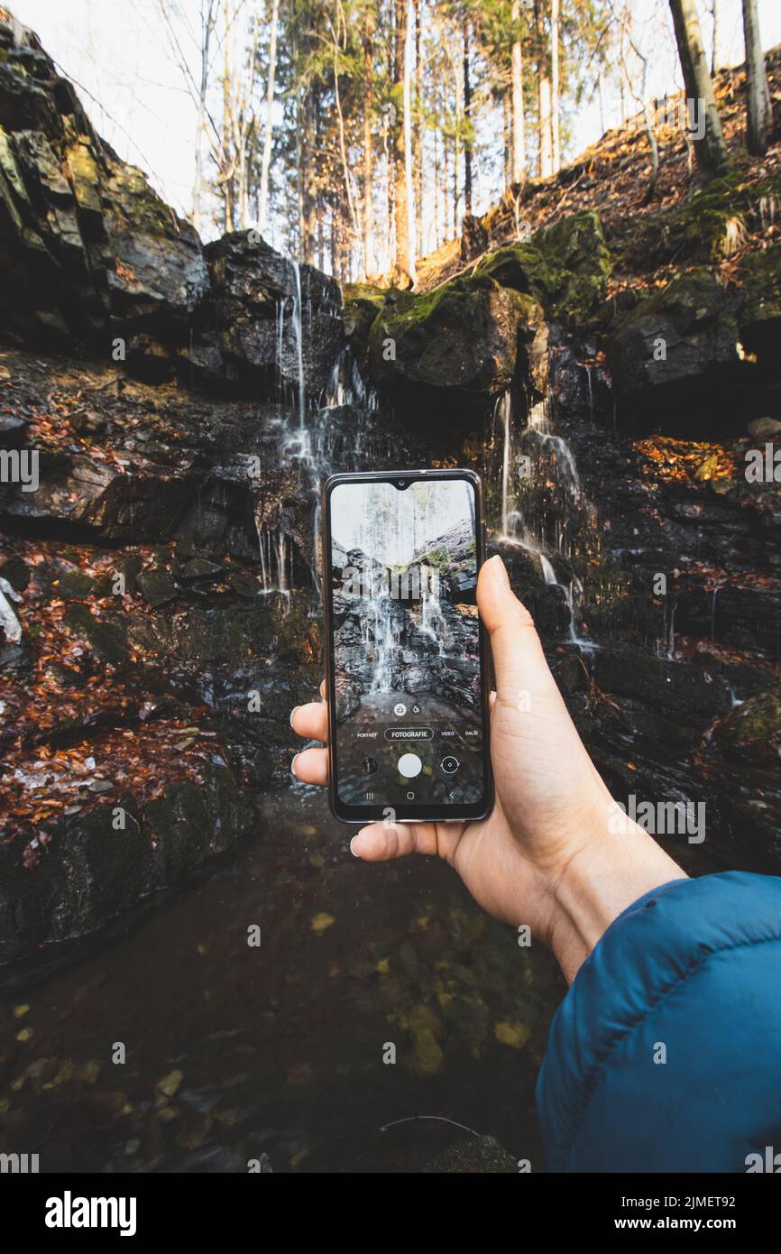 Tourist prend une photo de la cascade de Tosanovsky sur son téléphone ...