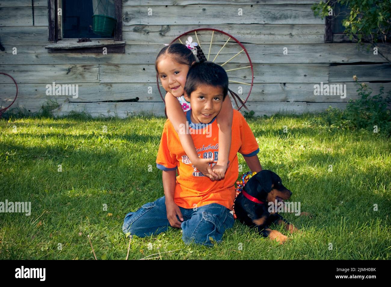 Tandis que les enfants amérindiens jouent avec un chiot, une sœur met ...