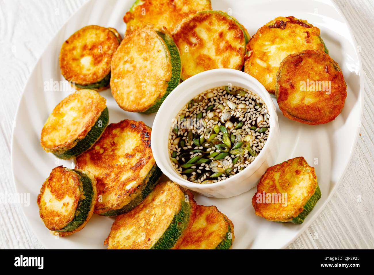 Courgettes poêlées en pâte à œufs servies avec sauce soja sur une ...