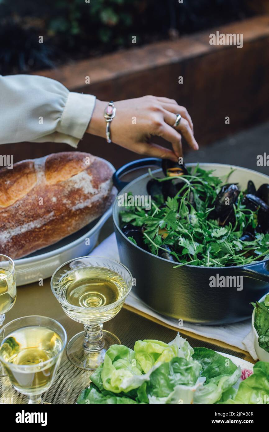 main de femme se faisant tendre vers l'extérieur pour prendre la moule ...