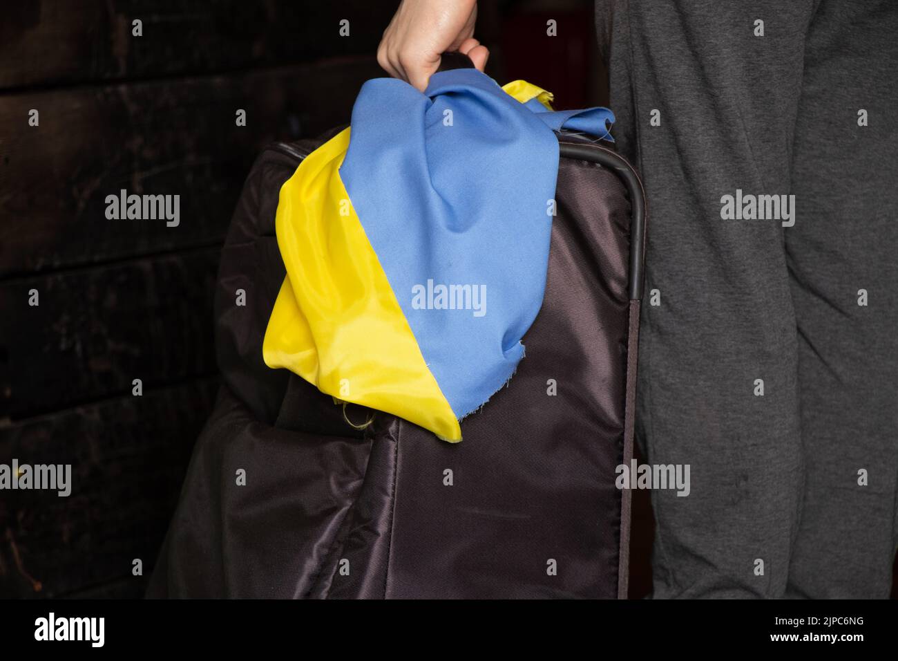 Une femme ukrainienne avec une valise et un drapeau de l'Ukraine quitte ... Une femme ukrainienne avec une valise et un drapeau de l'Ukraine quitte ...