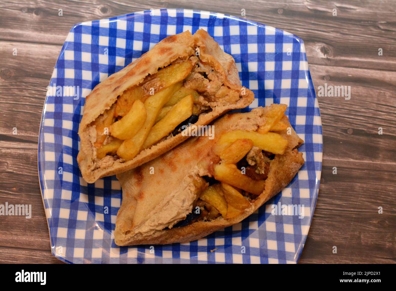 Un pain plat pitta rempli d'un mélange de pommes de terre frites, de ...