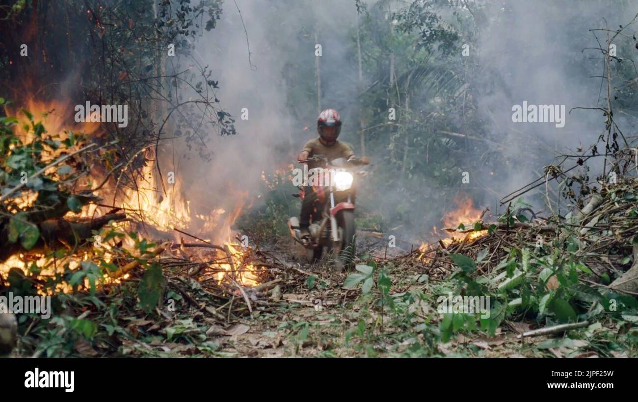 LE TERRITOIRE, un envahisseur conduit sa moto à travers le feu de pluie ...