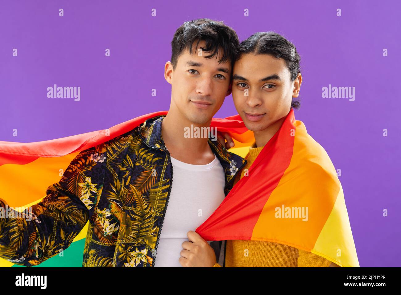 Portrait d'un couple biracial heureux qui embrasse et tient le drapeau ...