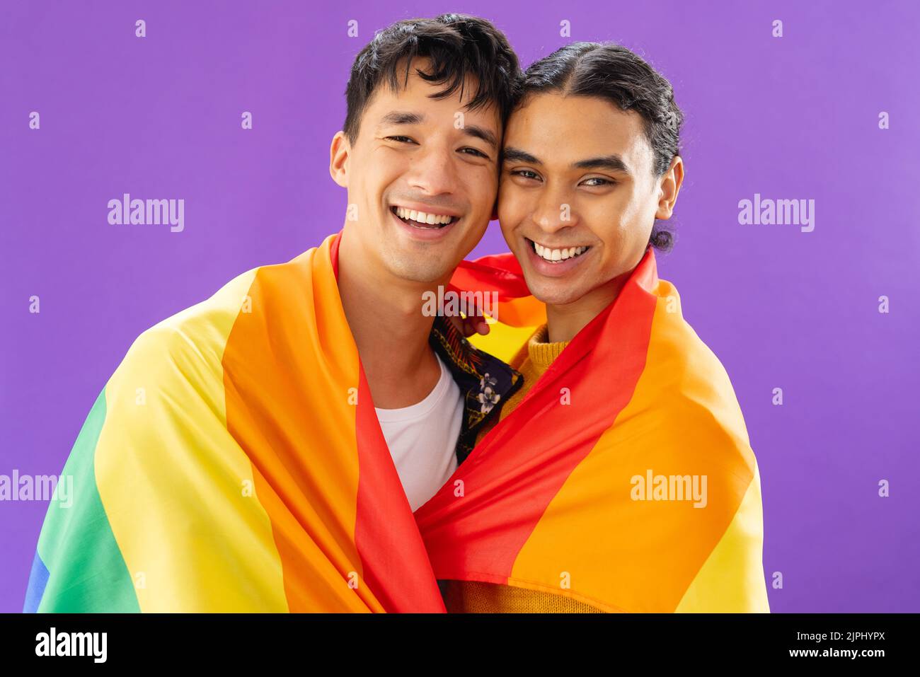 Portrait d'un couple biracial heureux qui embrasse et tient le drapeau ...