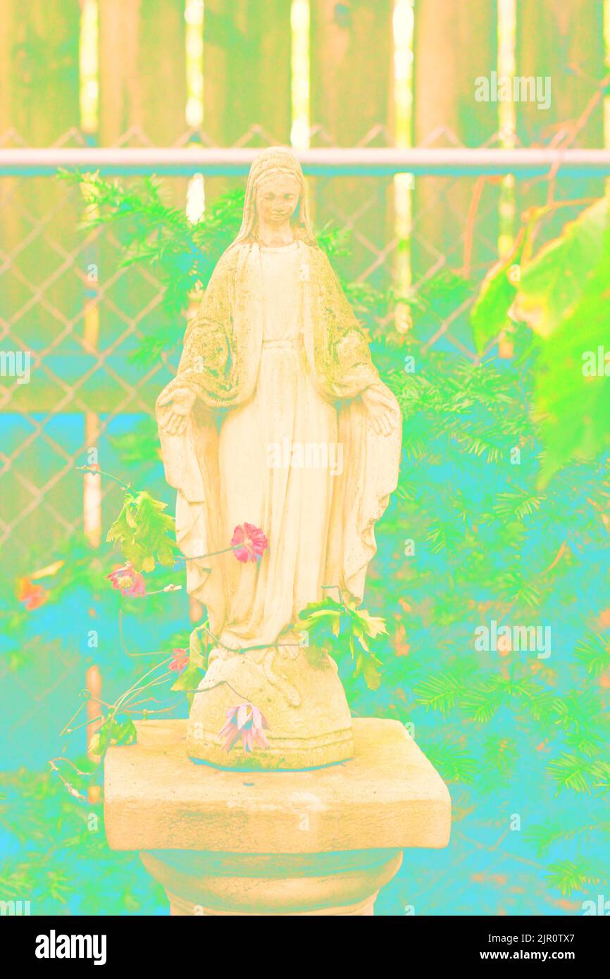 Une statue de la Vierge Marie se tenant dans un jardin d'été dans une ...