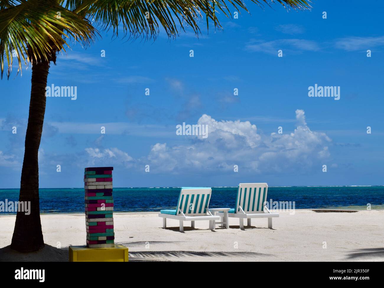 Une plage tranquille avec des chaises longues, du sable blanc, un ...