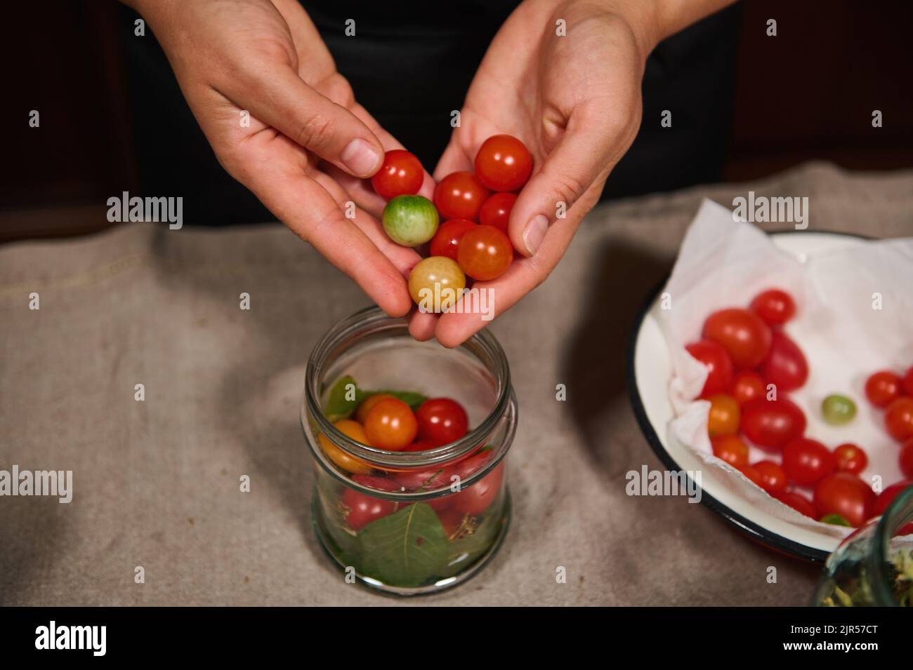 Détails: Mains de la femme de ménage tenant une poignée de tomates ...