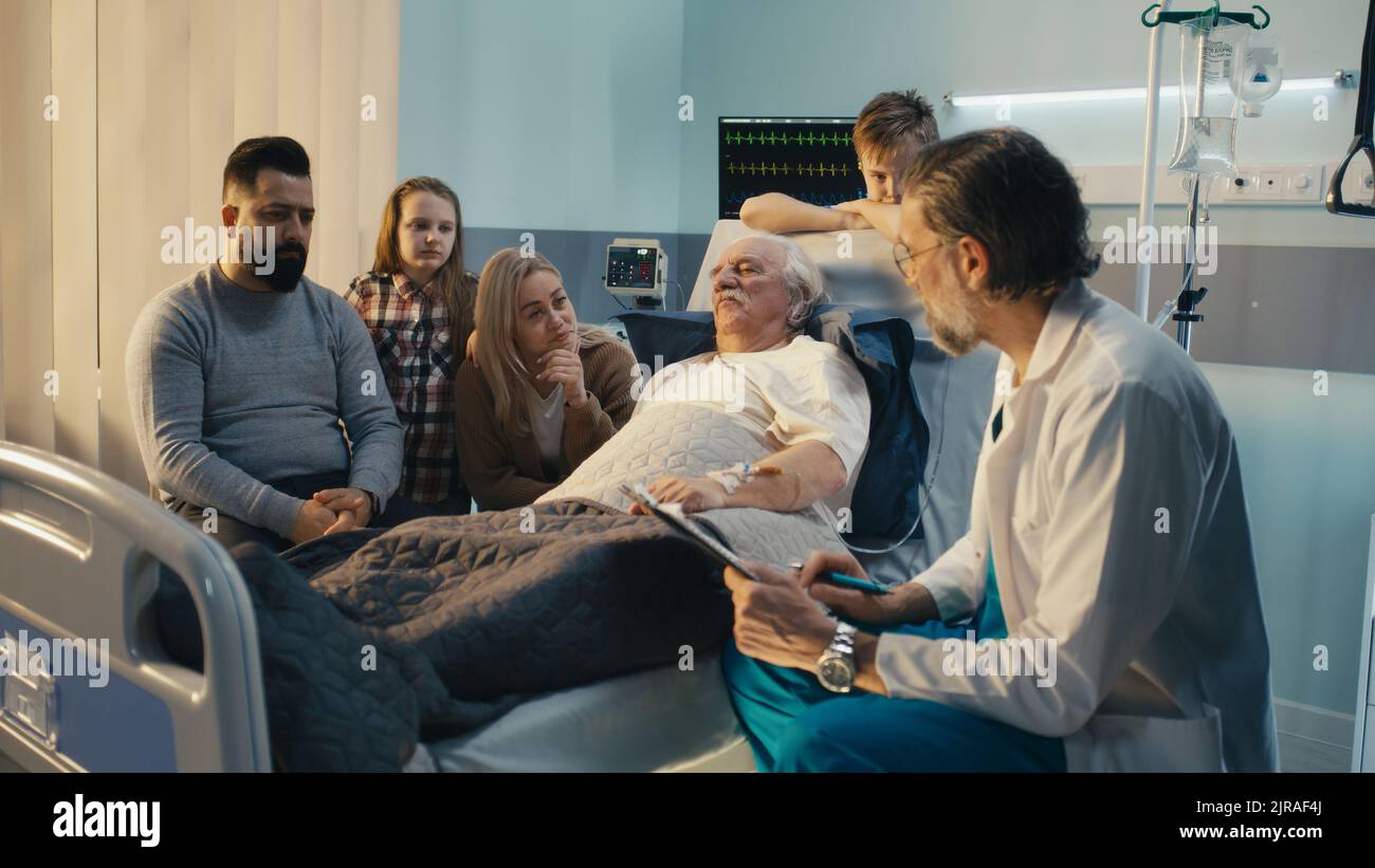Un médecin mature pose des questions au patient et à la famille âgés et ...