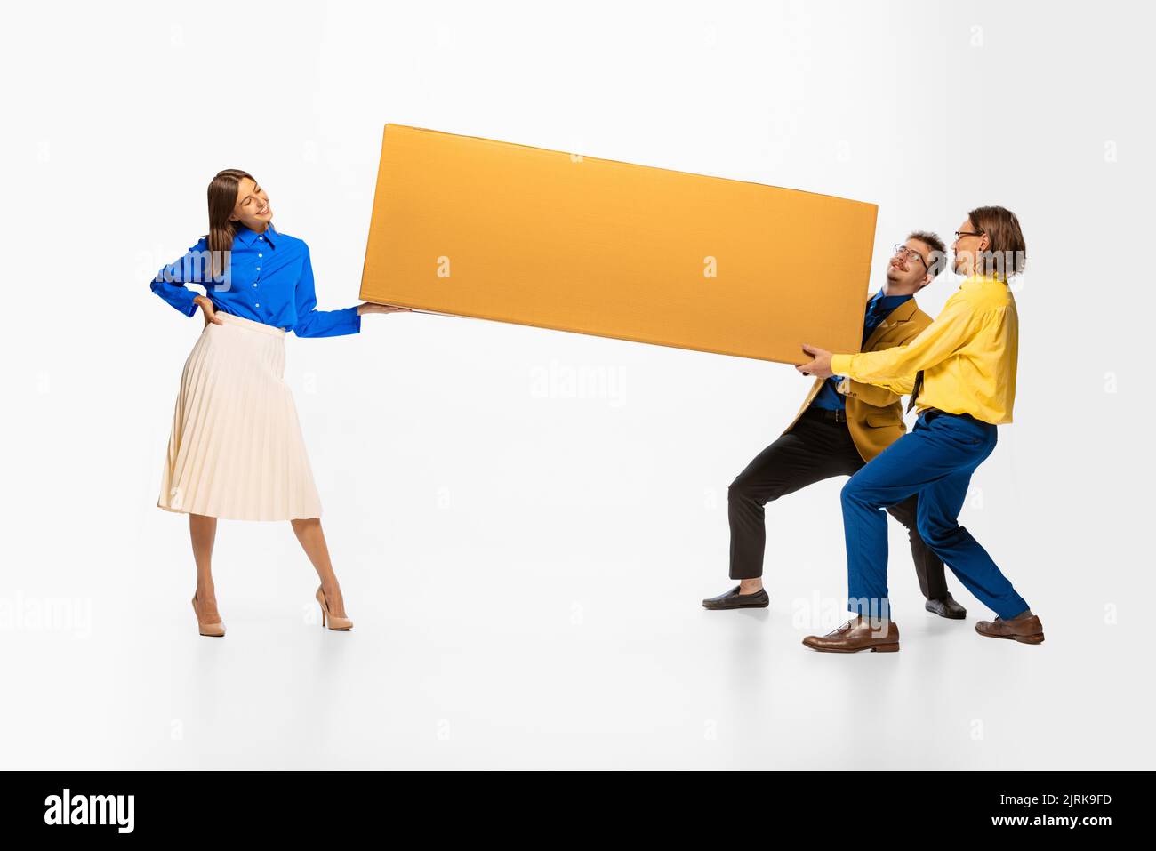Jeunes hommes portant une boîte en carton géante isolée sur fond blanc ...