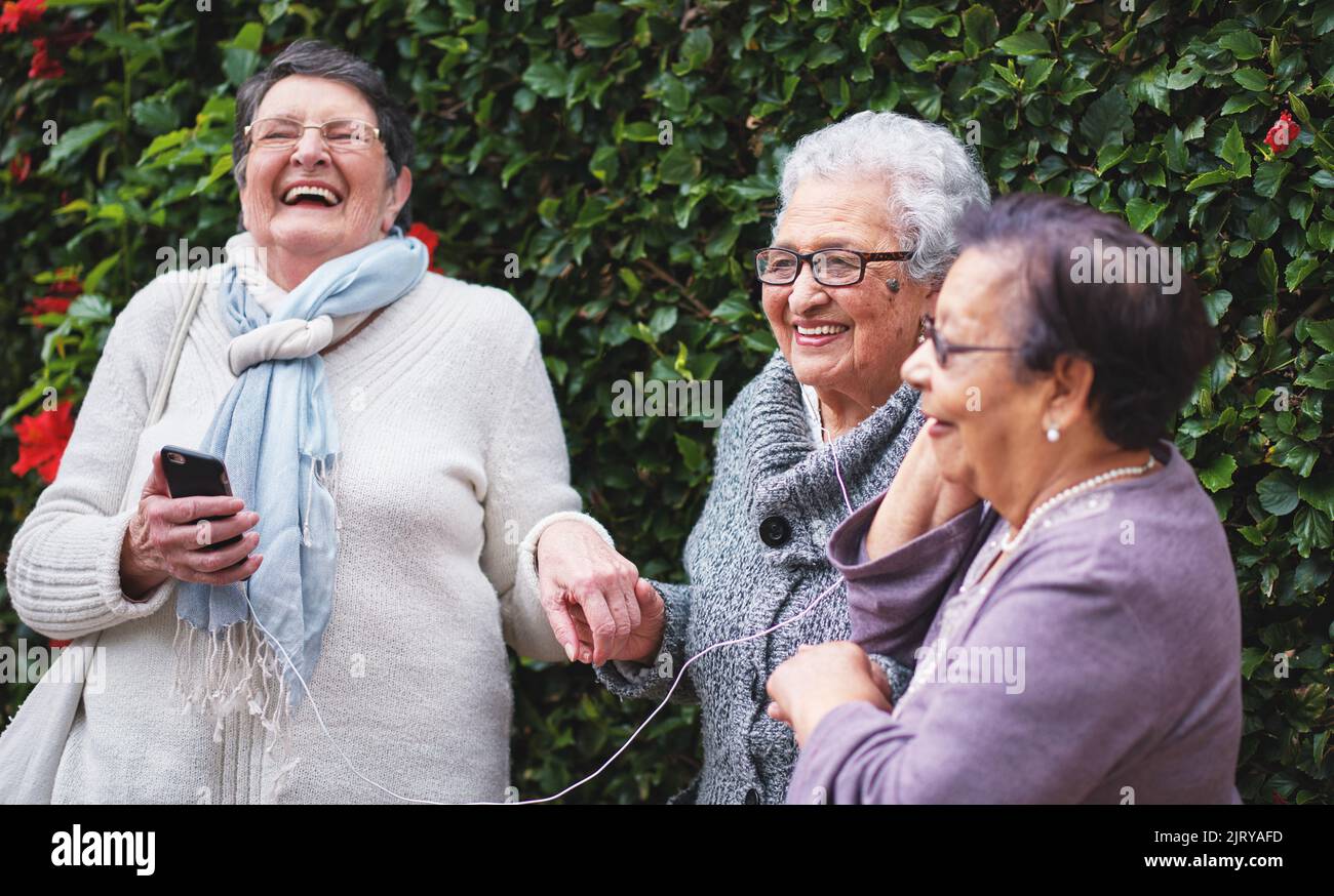 Des femmes âgées drôles qui écoutent de la musique sur leur smartphone ... Des femmes âgées drôles qui écoutent de la musique sur leur smartphone ...