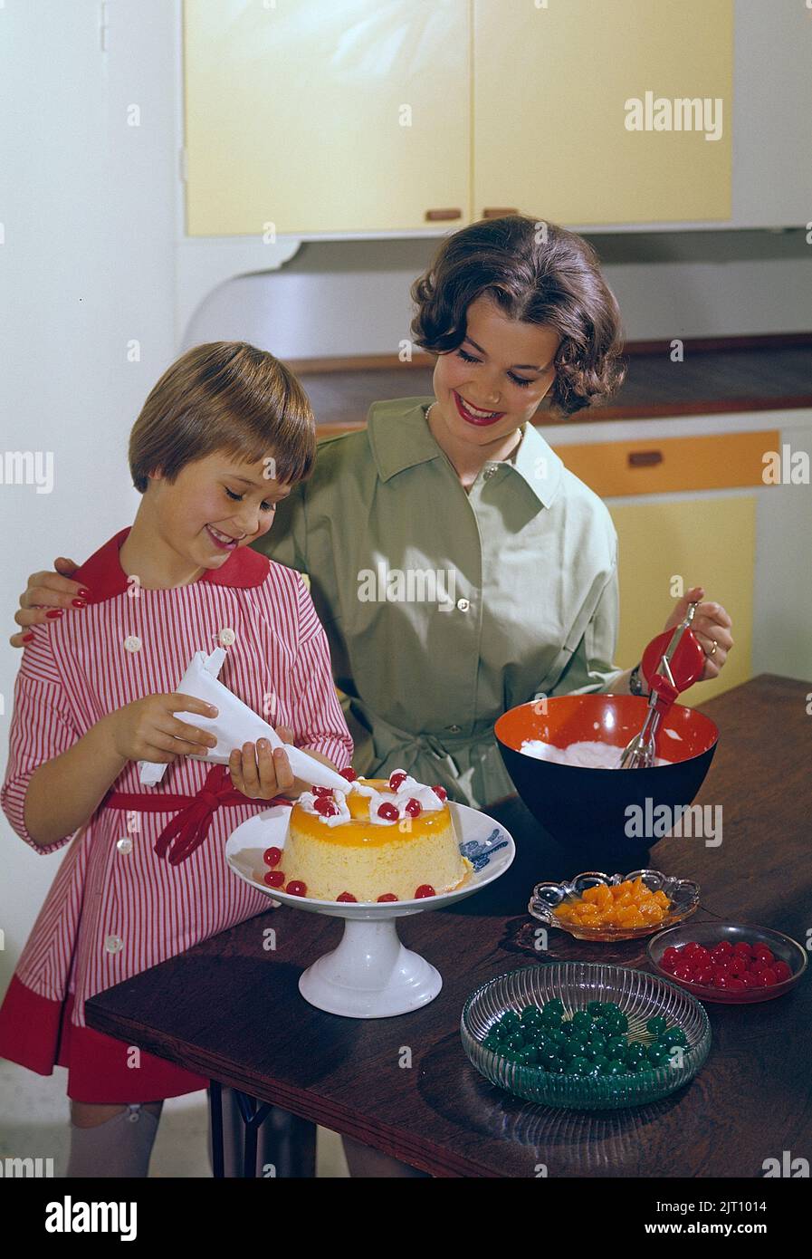 Cuire un gâteau dans le 1950s. Une mère et sa fille dans la cuisine ... Cuire un gâteau dans le 1950s. Une mère et sa fille dans la cuisine ...