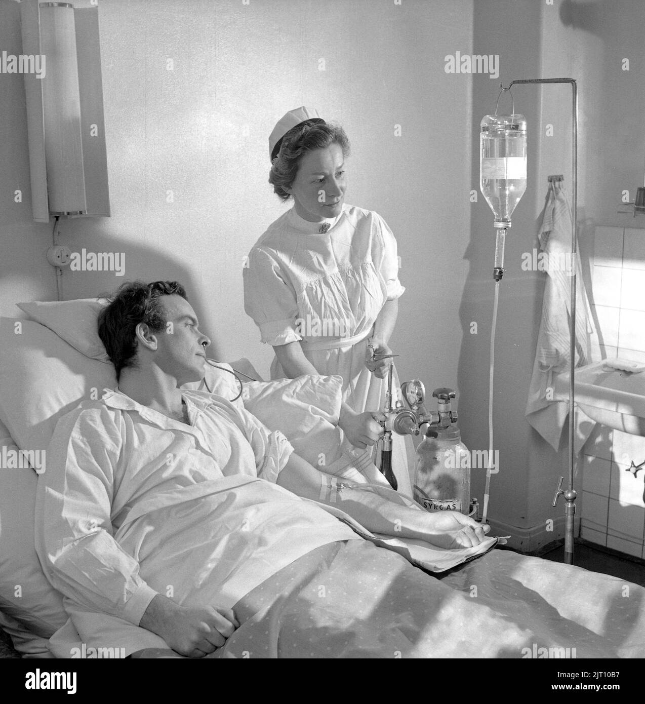 Hôpital dans le 1950s. Une infirmière ajuste l'oxygène qui est ...