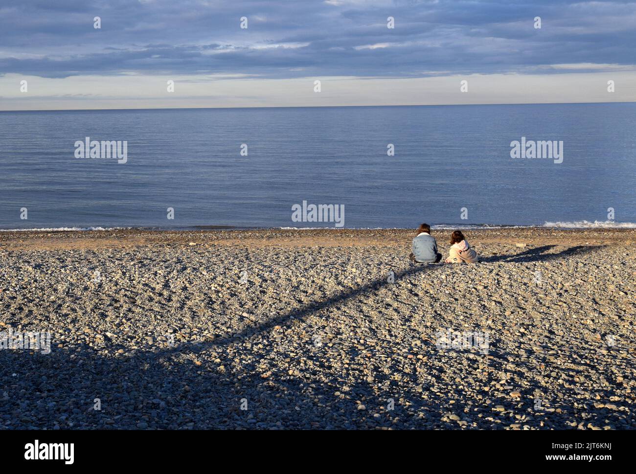 Deux personnes assises sur la plage Banque de photographies et d’images ...