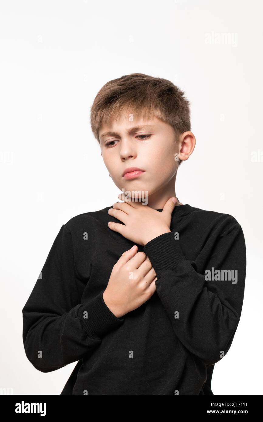 L'enfant a un mal de gorge, l'enfant tient sa gorge avec ses mains, les ...