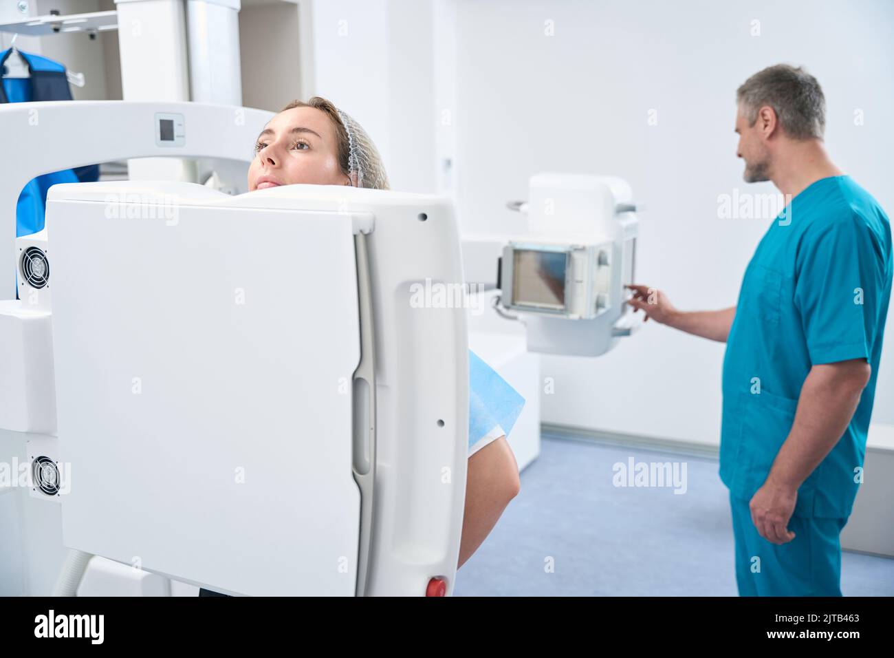 Femme en salle de radiographie subissant une procédure de radiographie ...
