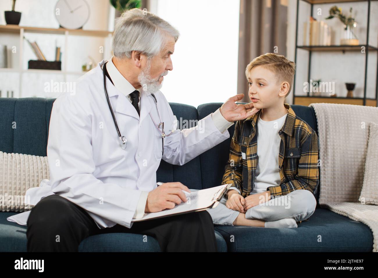 Un médecin mature groping vérifiant la douleur et l'enflure dans le cou ...