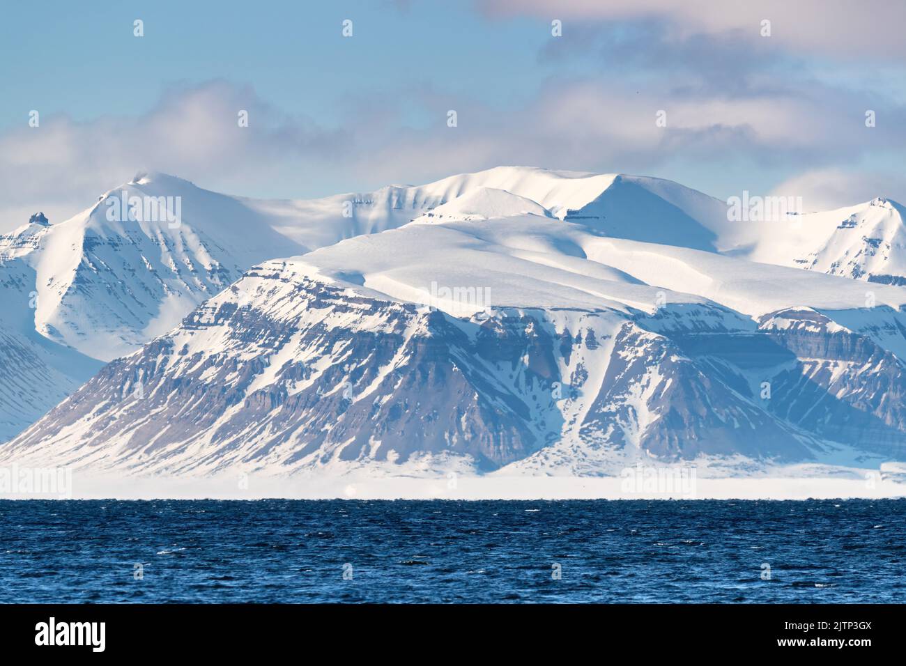 La neige immaculée couvrait les montagnes du Svalbard, un archipel norvégien entre la Norvège ...
