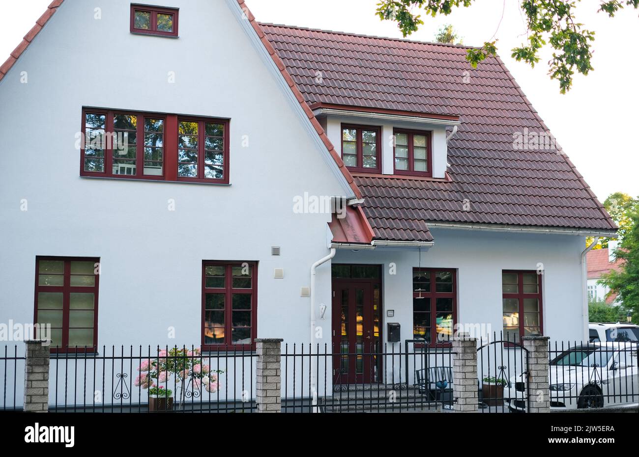 Une maison privée de deux étages avec un toit triangulaire et une zone ...