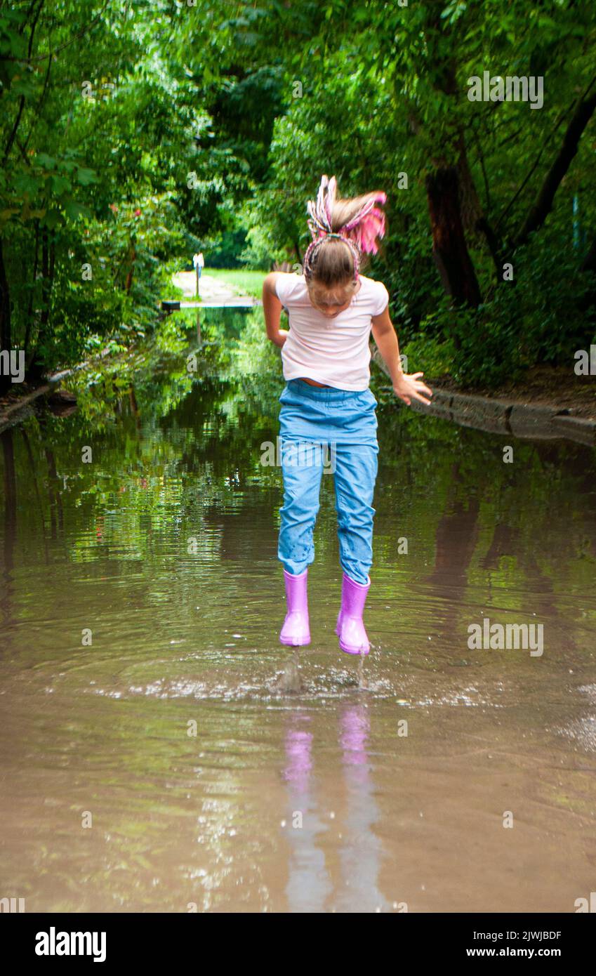 Enfant sautant dans une flaque d'eau Banque de photographies et d ...