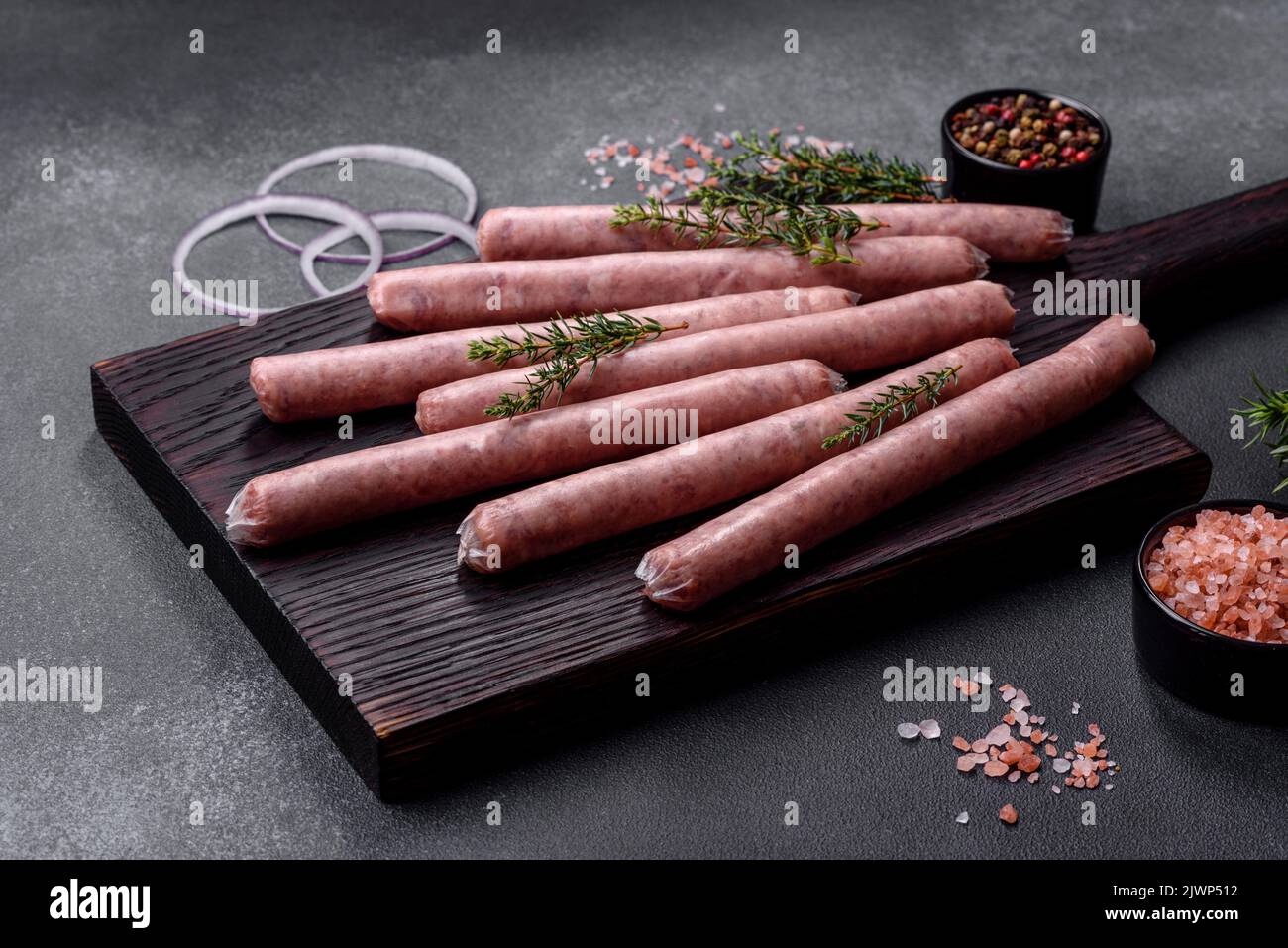 Les saucisses crues et les ingrédients pour la cuisine. Vue supérieure avec copie espace sur ...
