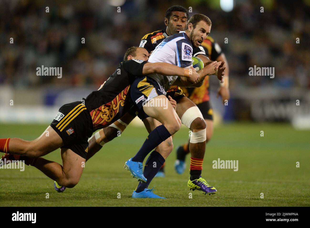 LE NIC White d'ACT Brumbies (au centre) est attaqué par Andrew Horrell ...