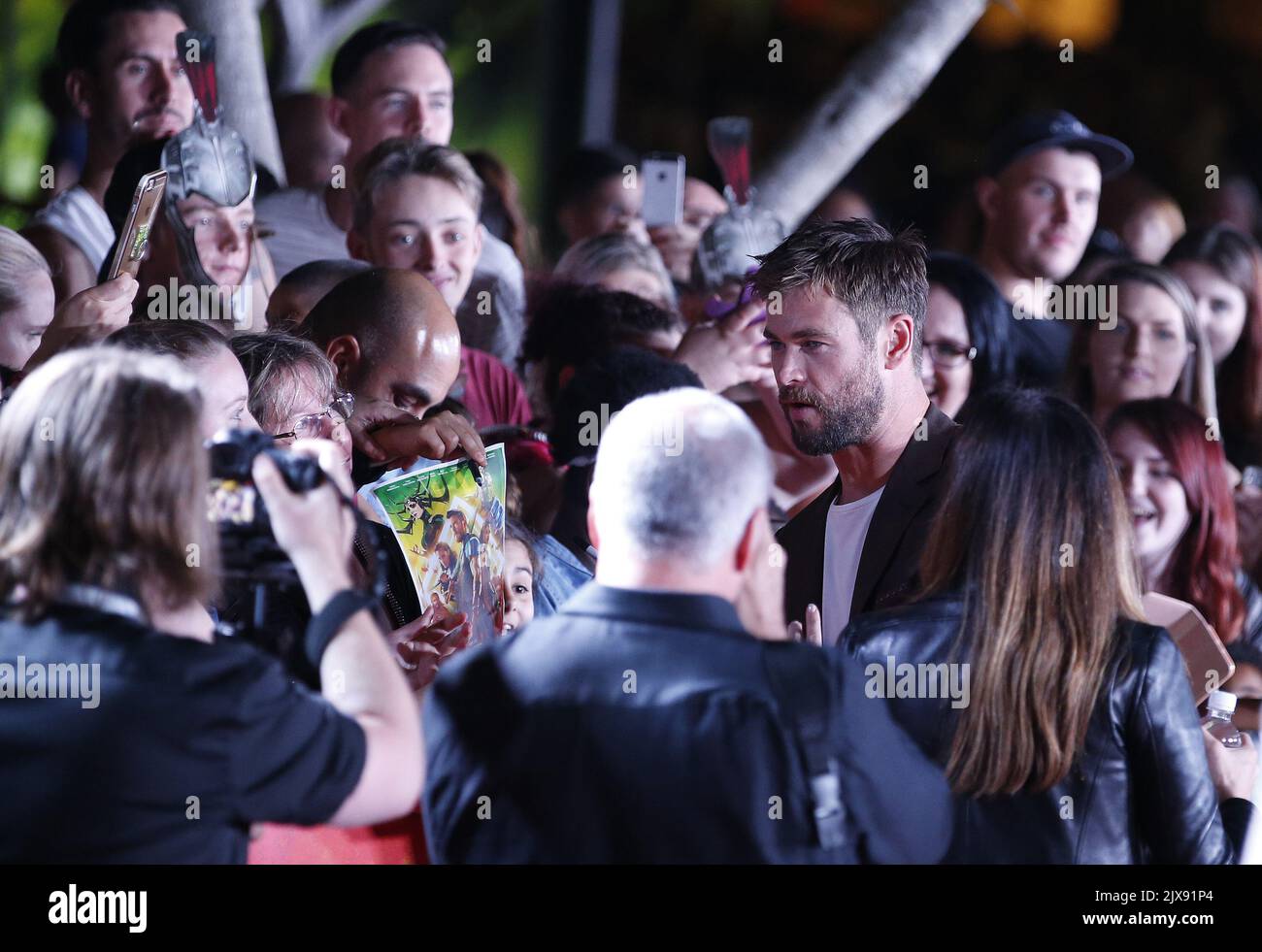 L'acteur Chris Hemsworth se mêle aux fans lorsqu'il marche sur le tapis ...