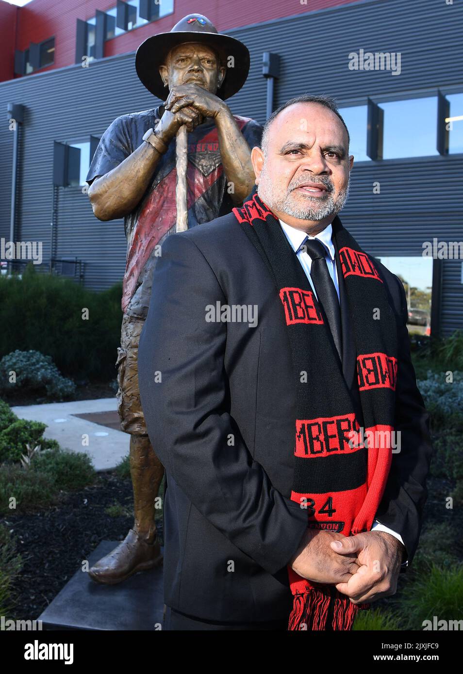 L'ancien joueur d'Essendon Michael long pose avec une statue de lui ...