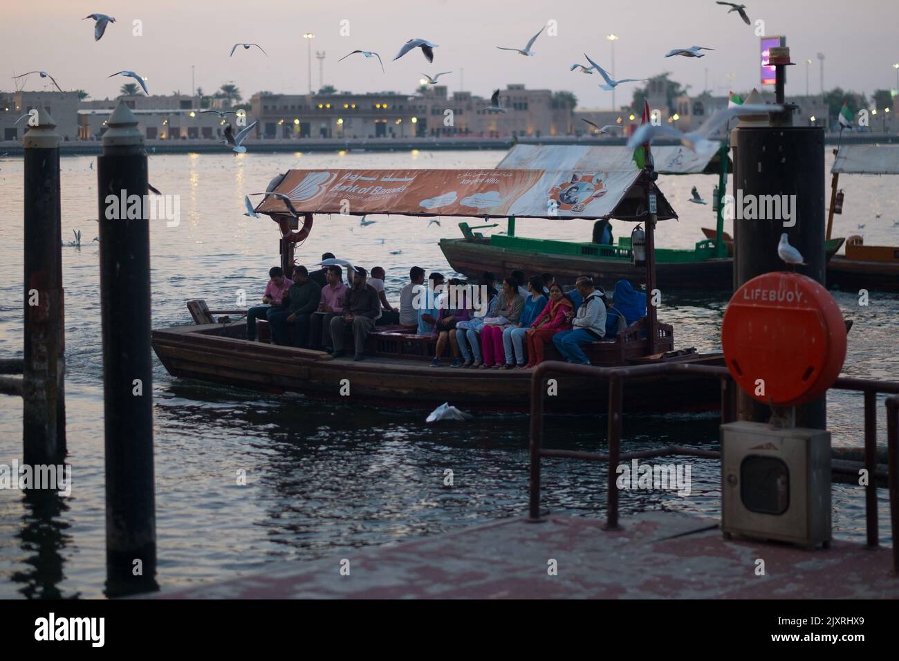 Les gens font un trajet en Abra, un bateau-taxi traditionnel qui ...