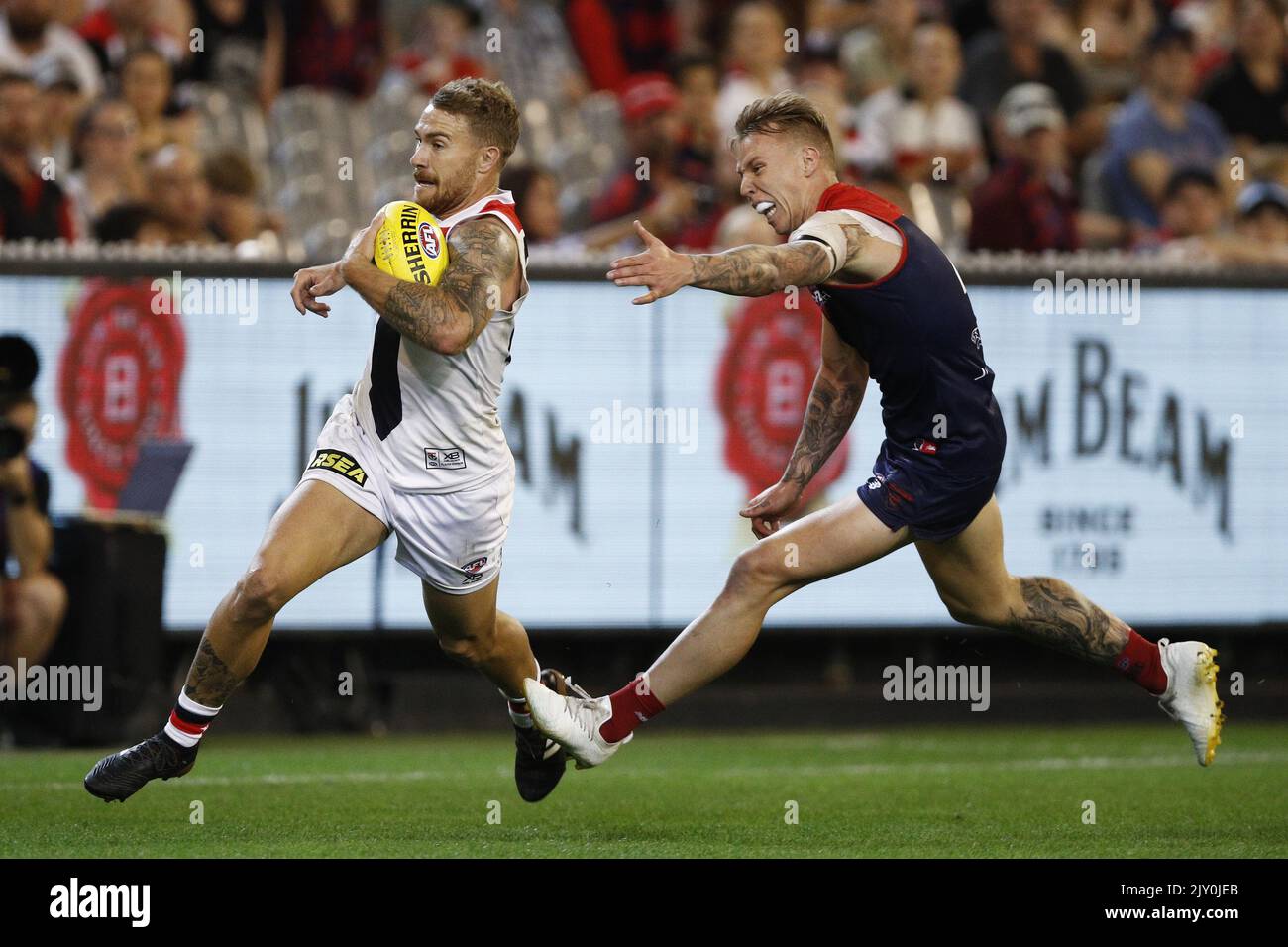 Dean Kent des Saints court avec le ballon loin de James Harmes des ...