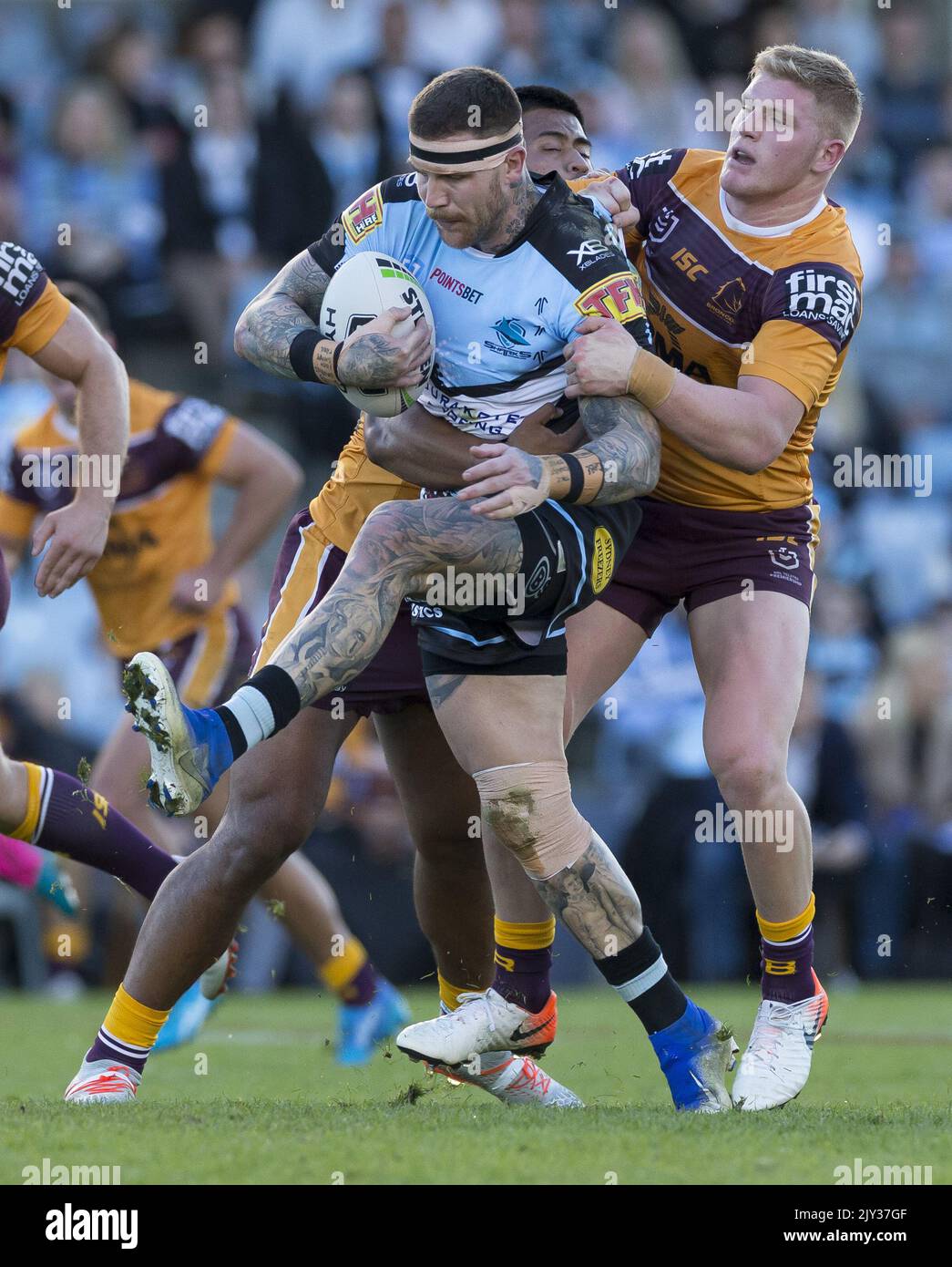 Josh Dugan des requins est attaqué pendant le match de la série 16 des ...