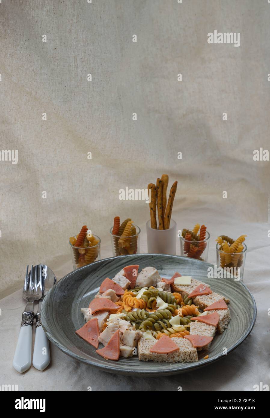 Fusilli au poulet et à la crevette avec fromage, saucisse et pain dans ...