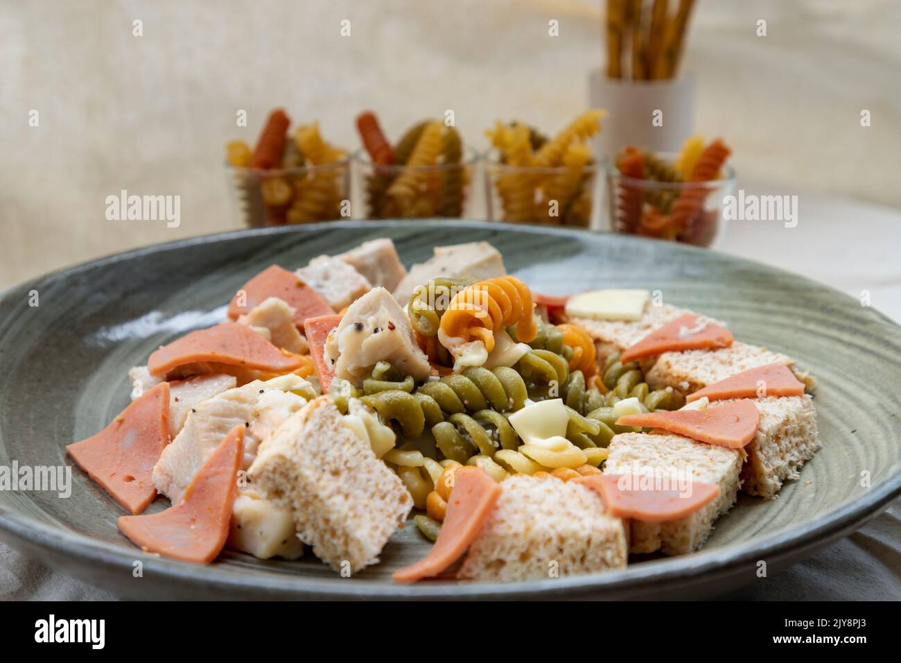 Fusilli au poulet et à la crevette avec fromage, saucisse et pain dans ...