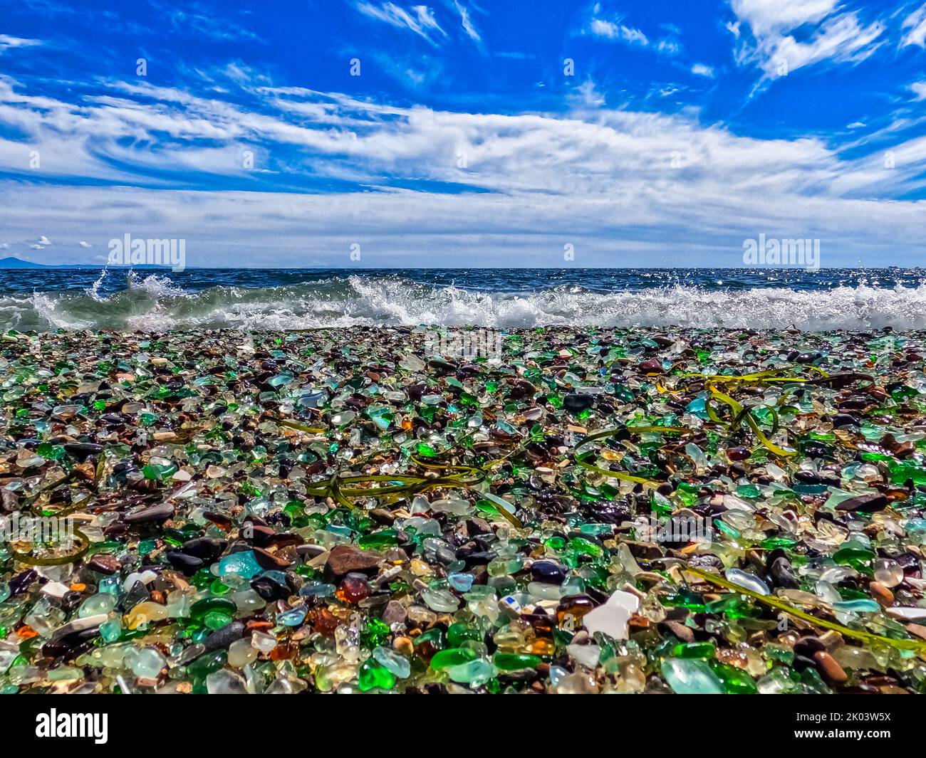 Verre de mer texturé à polir naturel et pierres sur le bord de mer. Eau ...