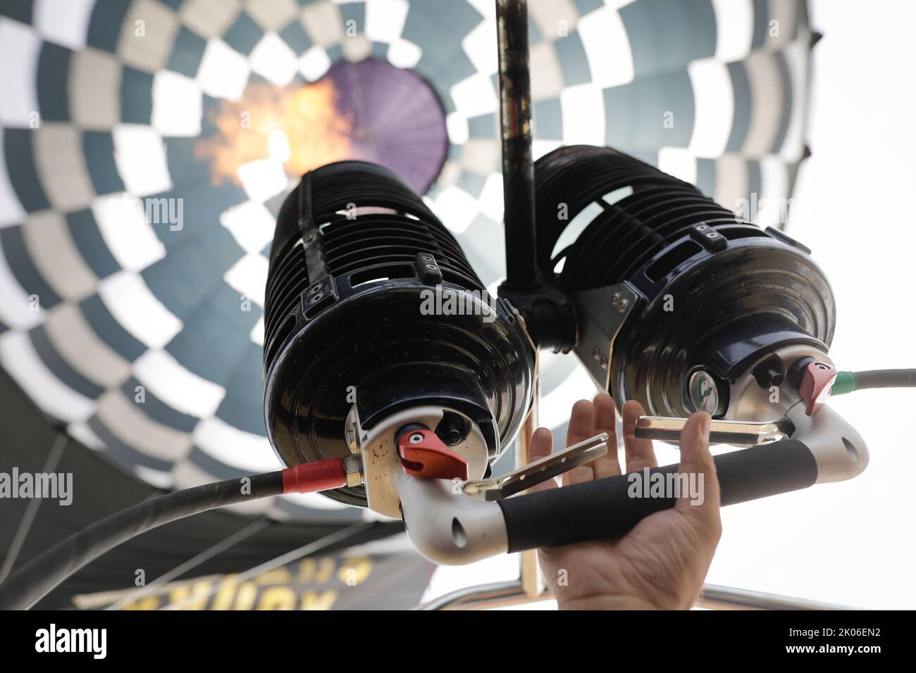 Un homme utilise un double brûleur à gaz pour gonfler un ballon d'air ...