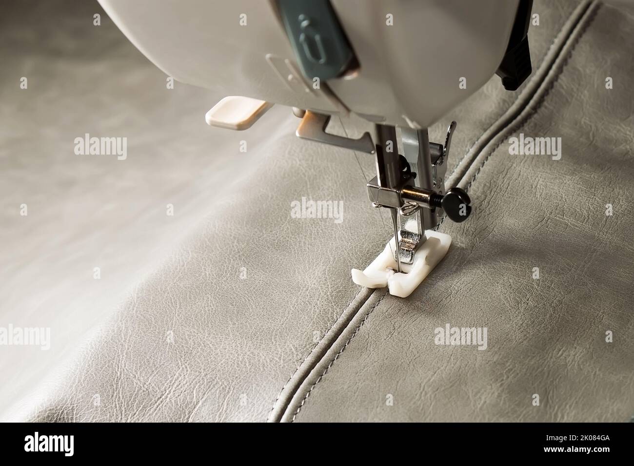 Machine à coudre moderne avec pied de presse spécial fait une couture ...