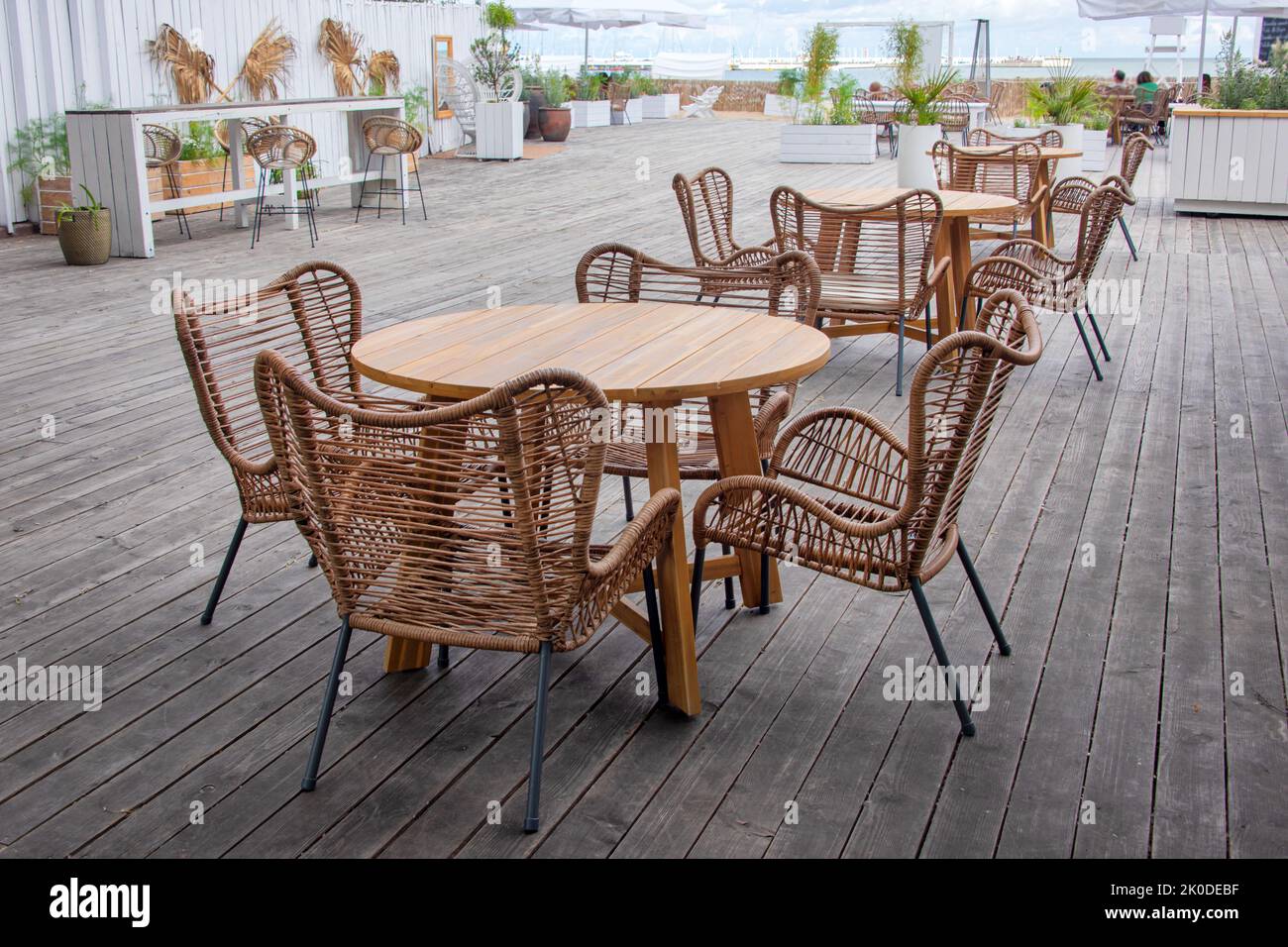 Café extérieur avec meubles en osier et tables en bois. Tables vides ...