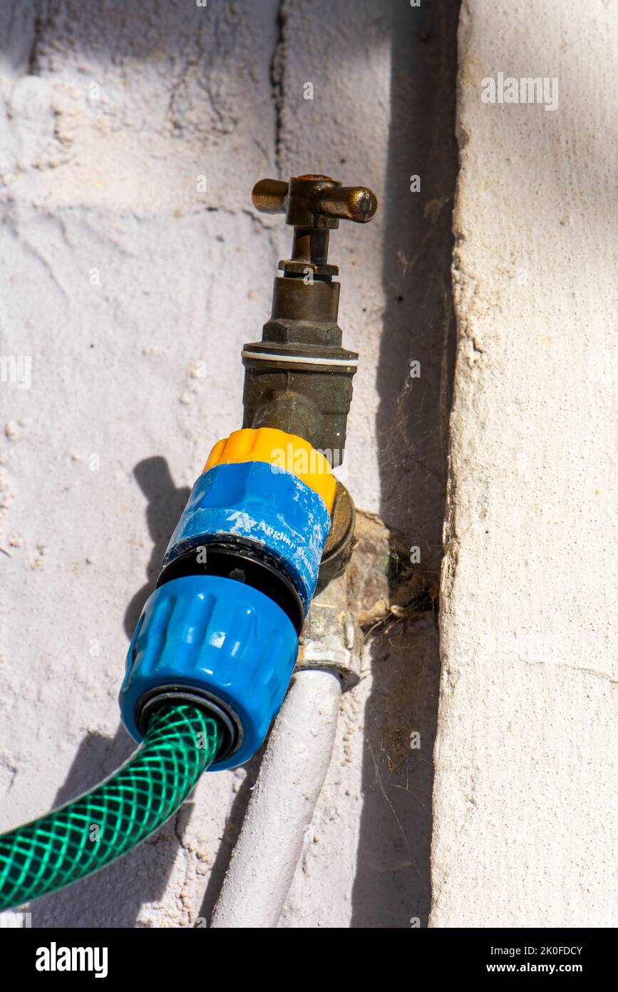 robinet extérieur sur un mur de jardin, tuyau flexible relié à un ...