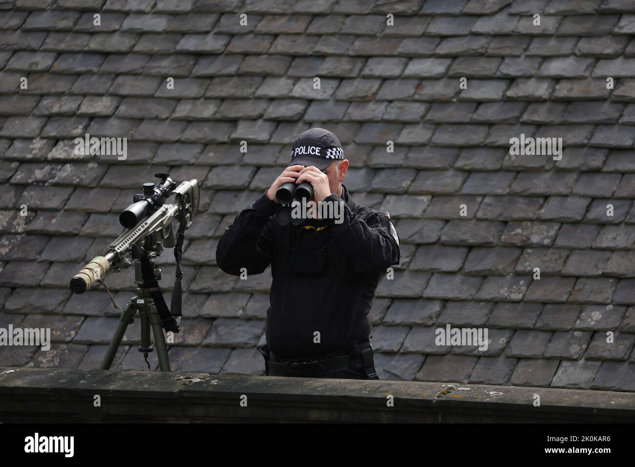 Un policier regarde à travers des jumelles avant le Service de prière ...