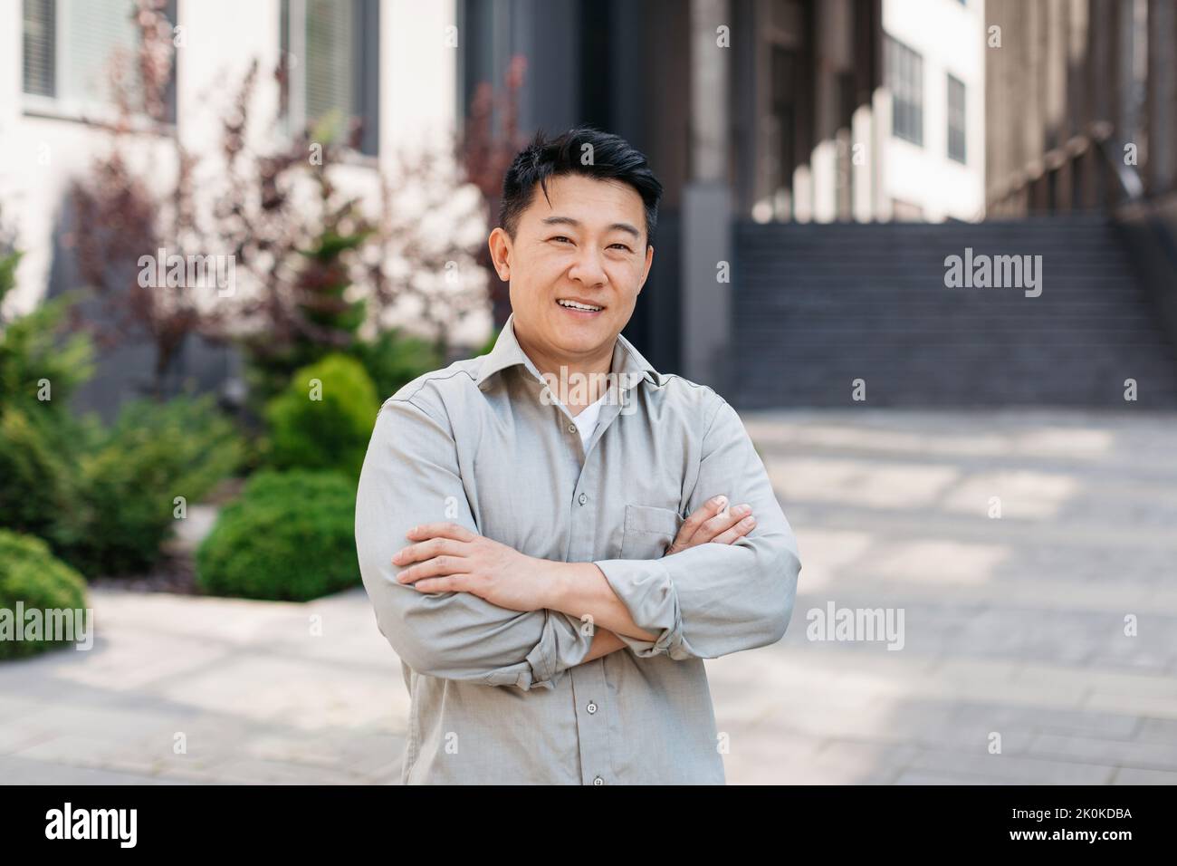 Portrait d'un entrepreneur asiatique confiant posant avec des bras ...