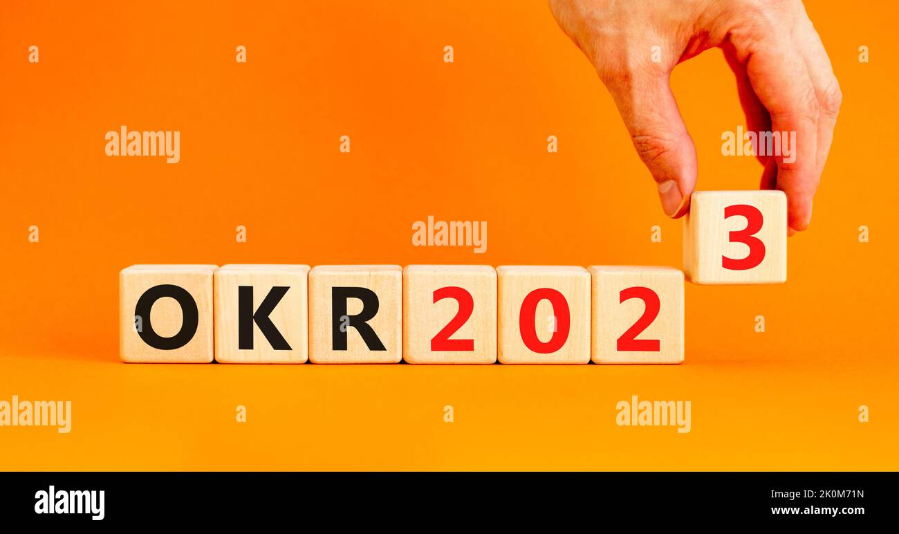 Symbole OKR, objectifs et résultats clés. Homme d'affaires transforme des cubes avec les mots ...