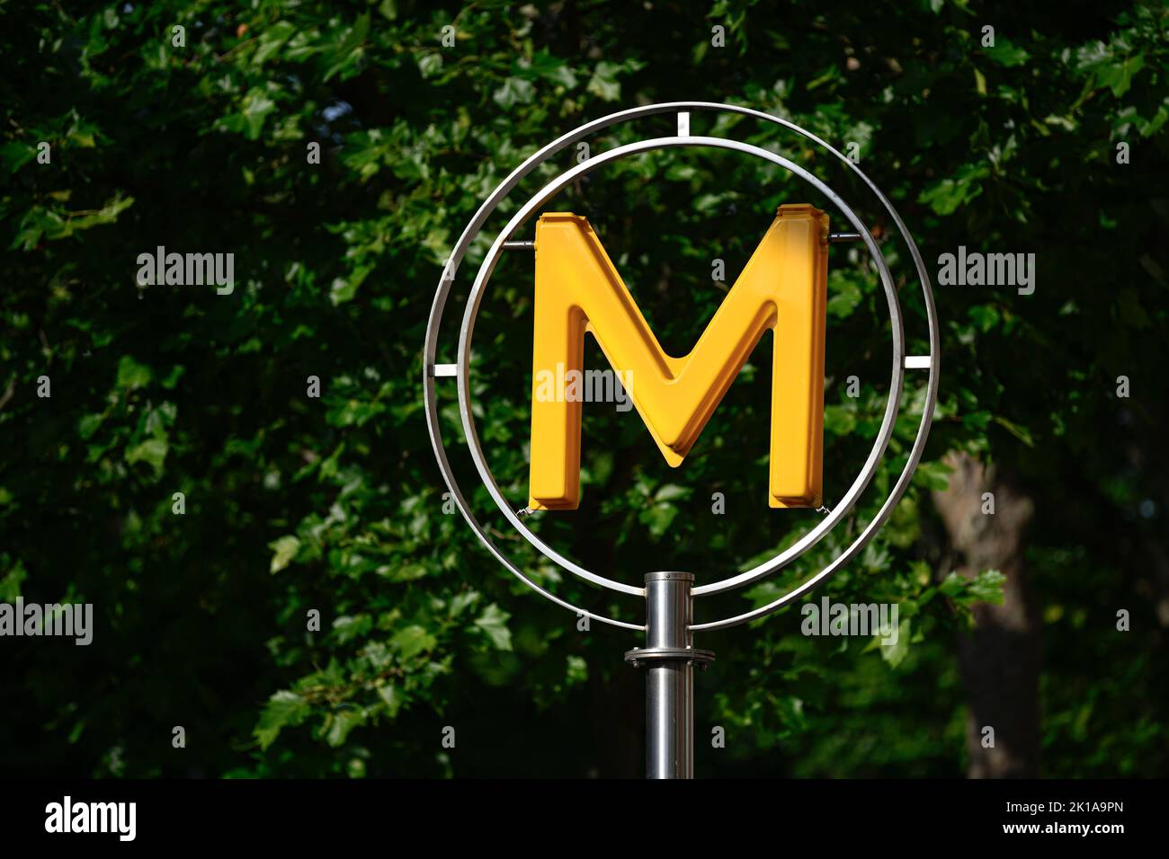 L'illustration montre un panneau avec le logo du métro (symbole jaune ...