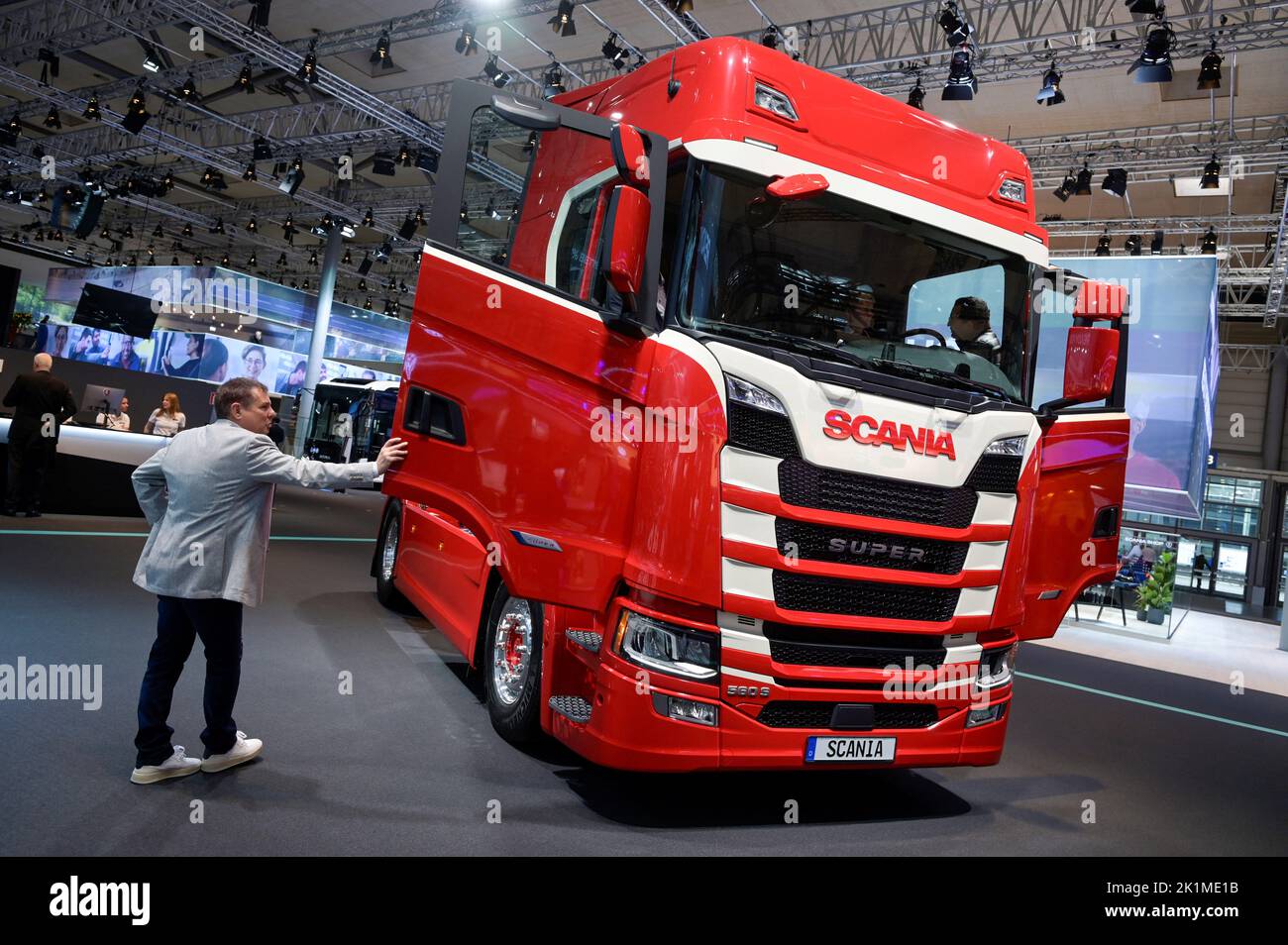 Un journaliste se tient à côté du nouveau camion Scania Super 13 litres ...