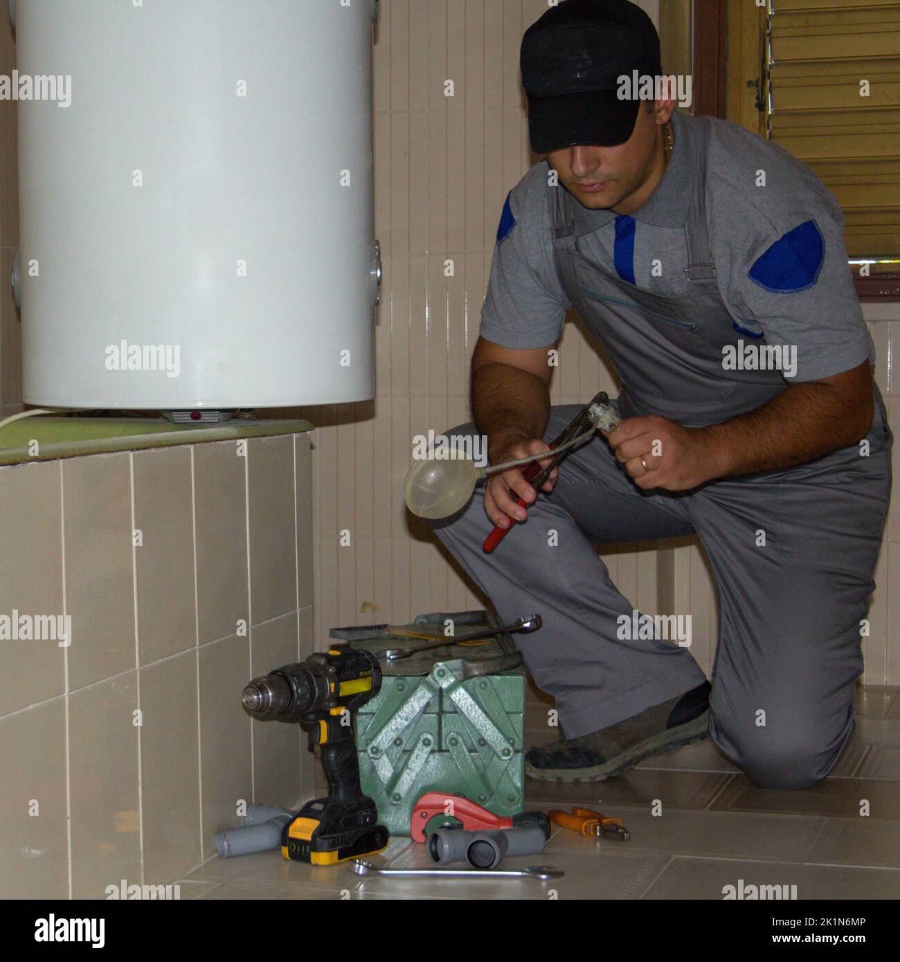 Plombier dans la salle de bains d'une maison qui, avec ses outils de ...