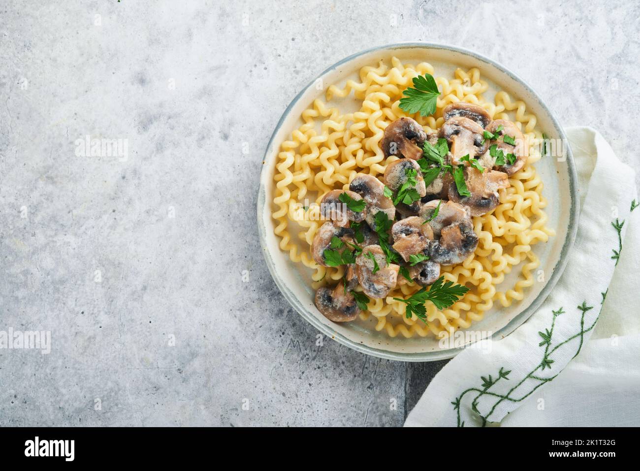 Pâtes fusilli avec champignons, fromage et sauce crémeuse à l'ail sur ...